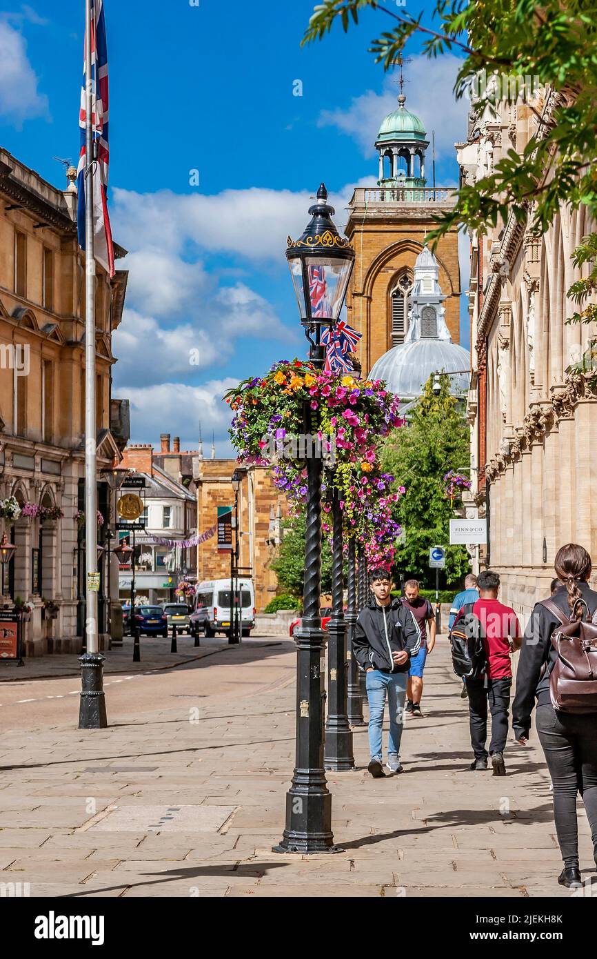 Lamp posts with colourful baskets of flowrers in St Giles Square ...