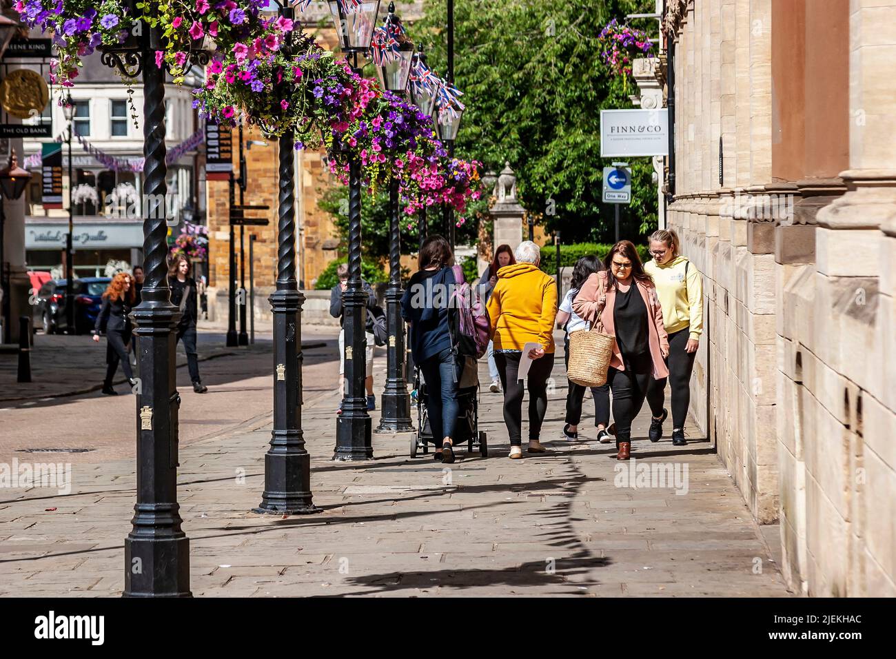 Lamp posts with colourful baskets of flowrers in St Giles Square ...