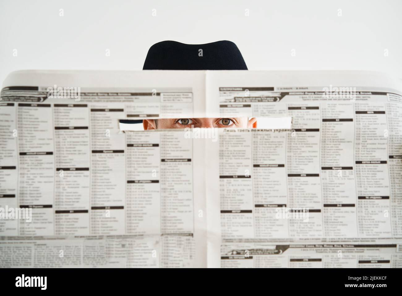 Private detective hiding watches through the newspaper over white ...