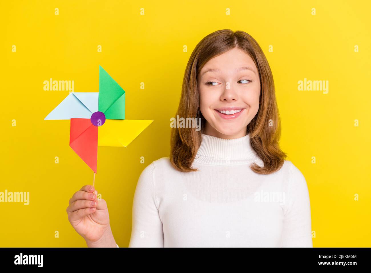 Photo of charming happy pretty little girl hold look windmill toy smile ...