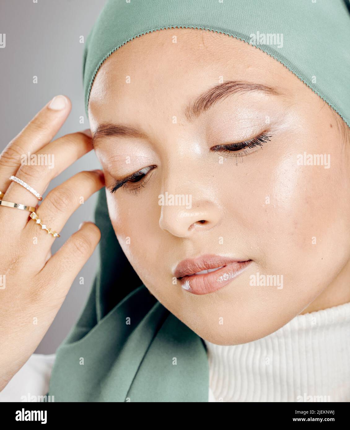 Closeup of a glowing beautiful muslim woman isolated against grey ...