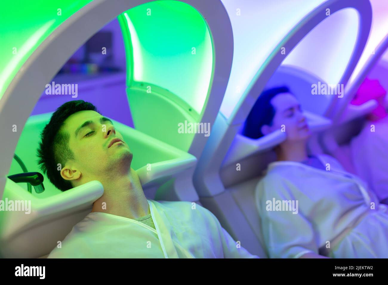 Glad male and female relaxing on massaging chairs Stock Photo - Alamy