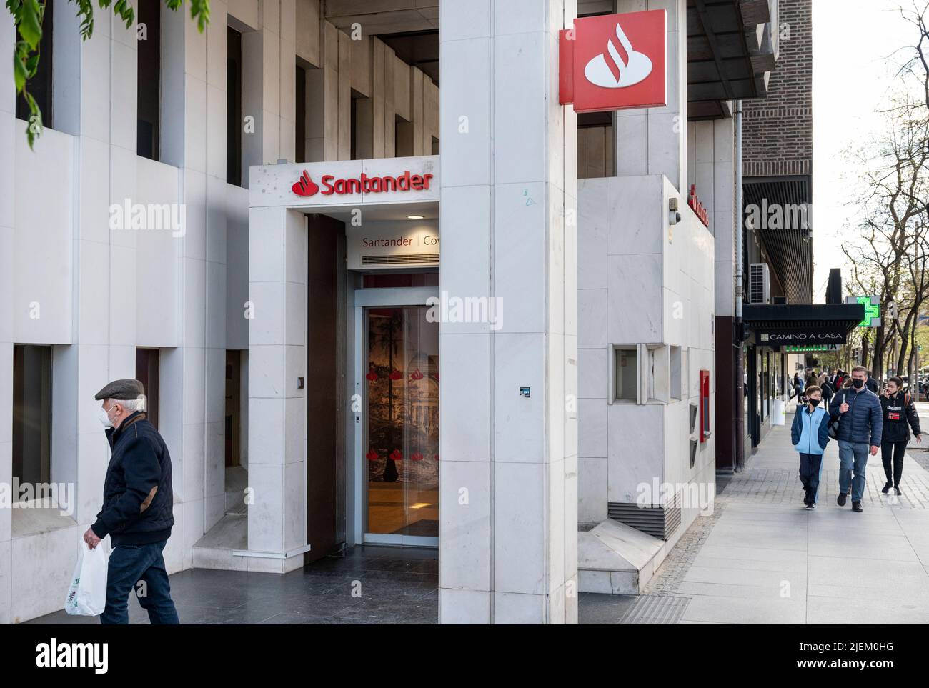 A pedestrian walks past the Spanish multinational commercial bank and ...