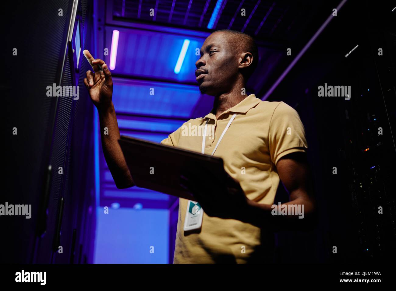 Low angle view at African American network engineer holding tablet in ...