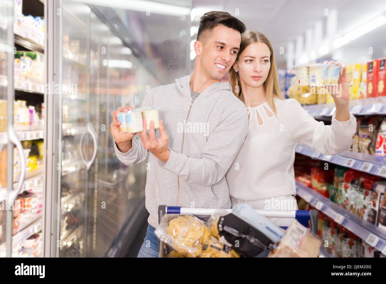 pair selecting yogurt and other dairy products Stock Photo - Alamy