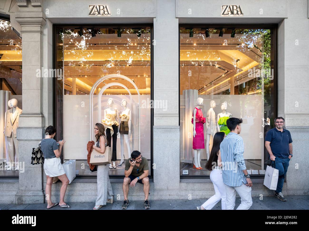 Pedestrians walk past the Spanish multinational clothing design retail ...