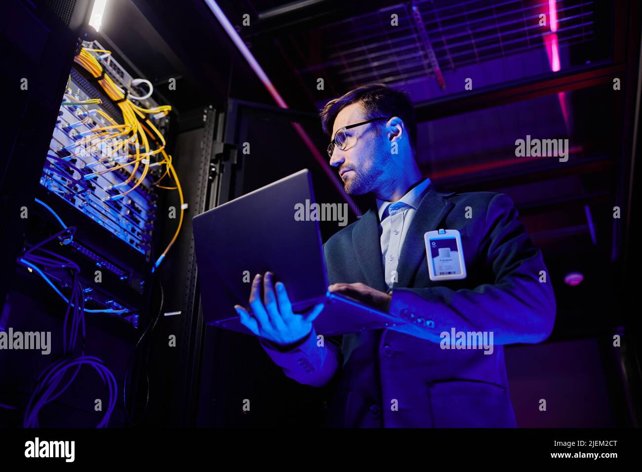 Low angle portrait of professional network engineer setting up servers ...