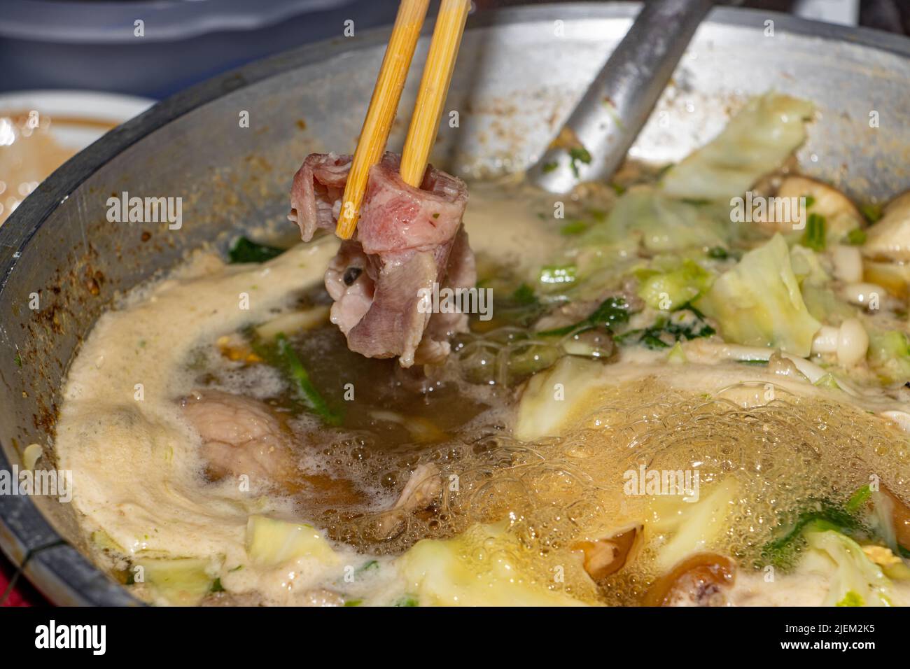 Preparing traditional Suki soup by cooking in a pot Stock Photo - Alamy