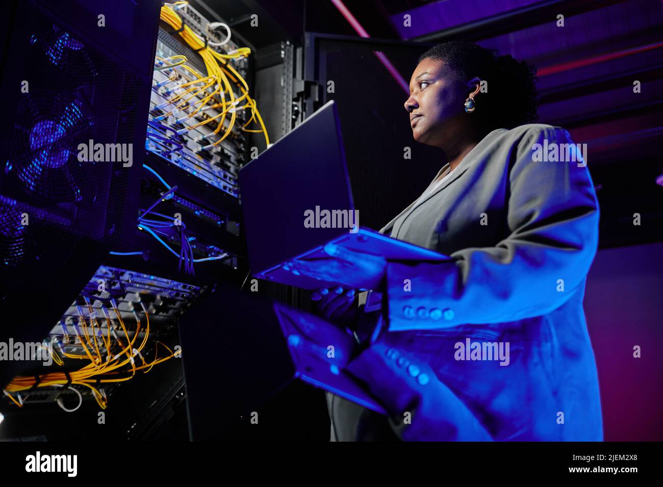 Low angle portrait of female network engineer setting up servers in ...