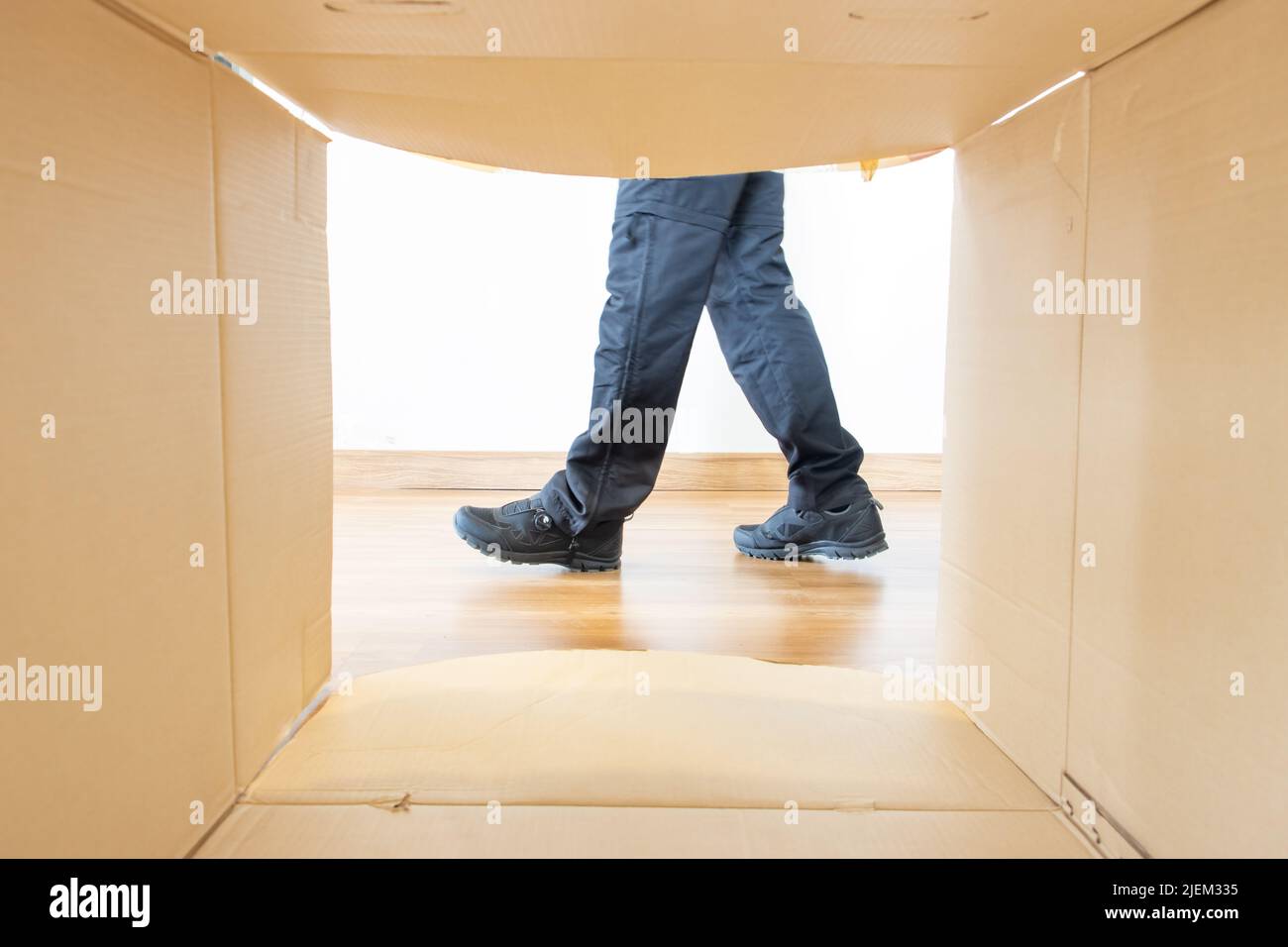 View through the cardboard box on a male legs walk on a floor Stock ...