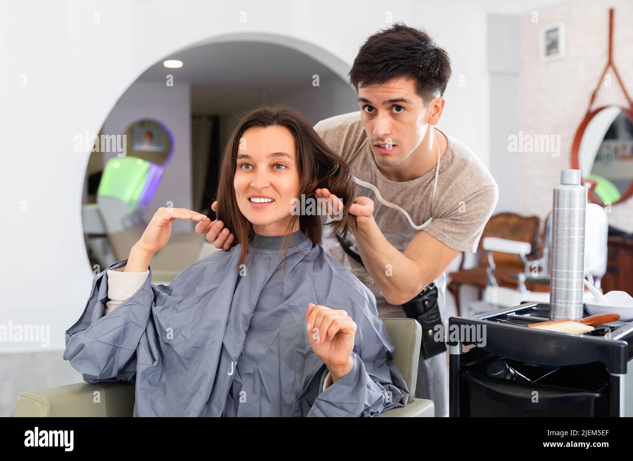 Happy young woman and hairdresser after haircut Stock Photo - Alamy