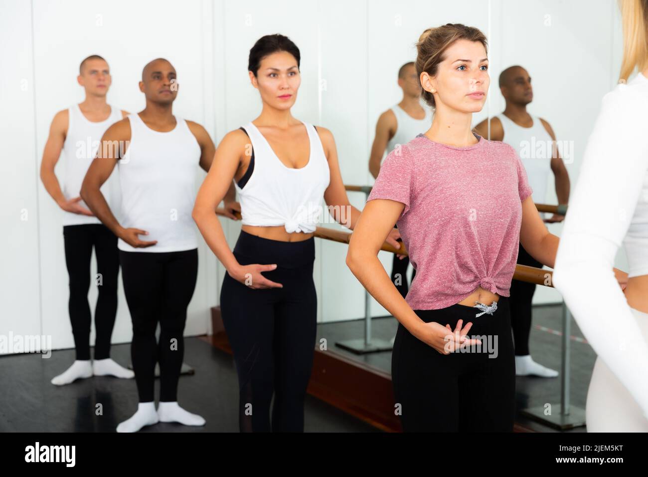 Women and men doing exercises on stretching ballet barre Stock Photo ...