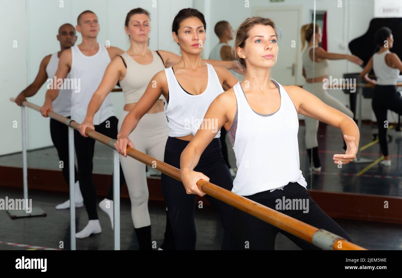dancers standing with one hand on barre and reaching over hand Stock ...