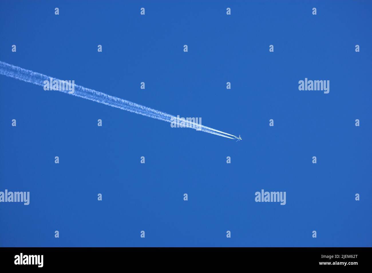 Airplane contrail against clear blue sky background with copyspace ...