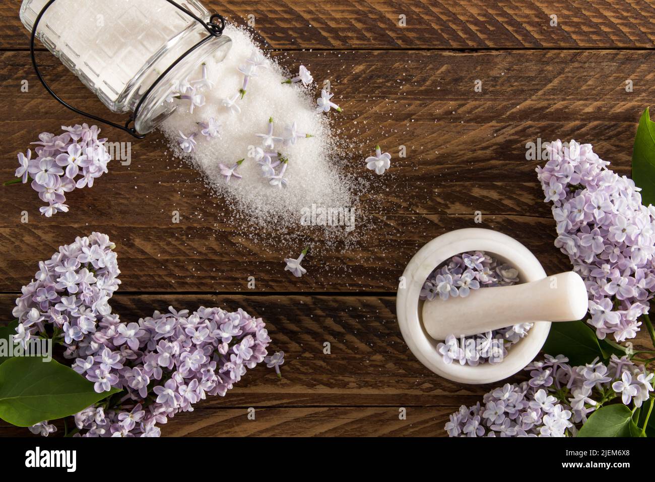 a glass jar with a scattering of lilac sugar, lilac branches and a ...