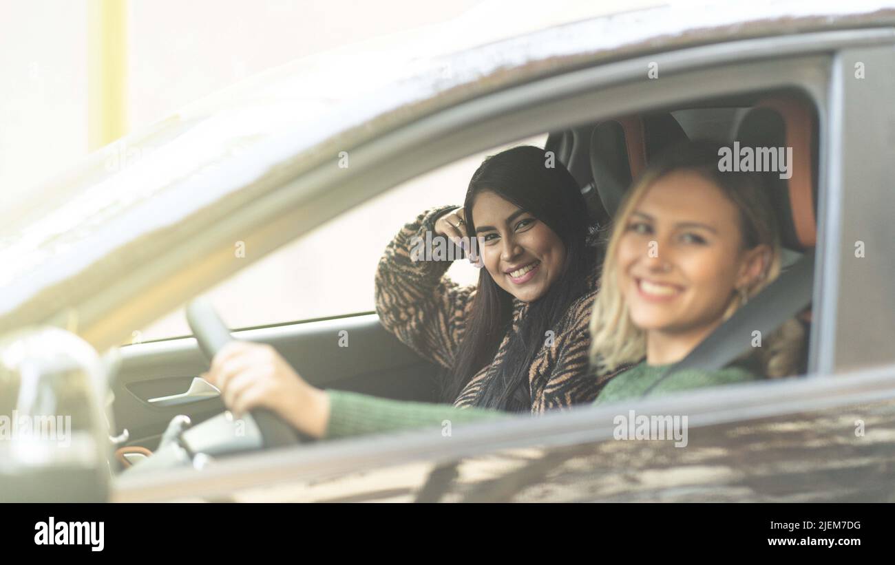 Two Young women smiling in a car enjoying a road tripping concept best ...