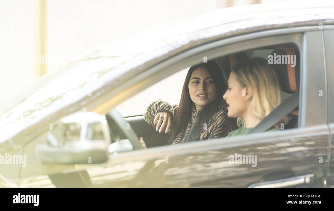Two Young women smiling in a car enjoying a road tripping concept best ...