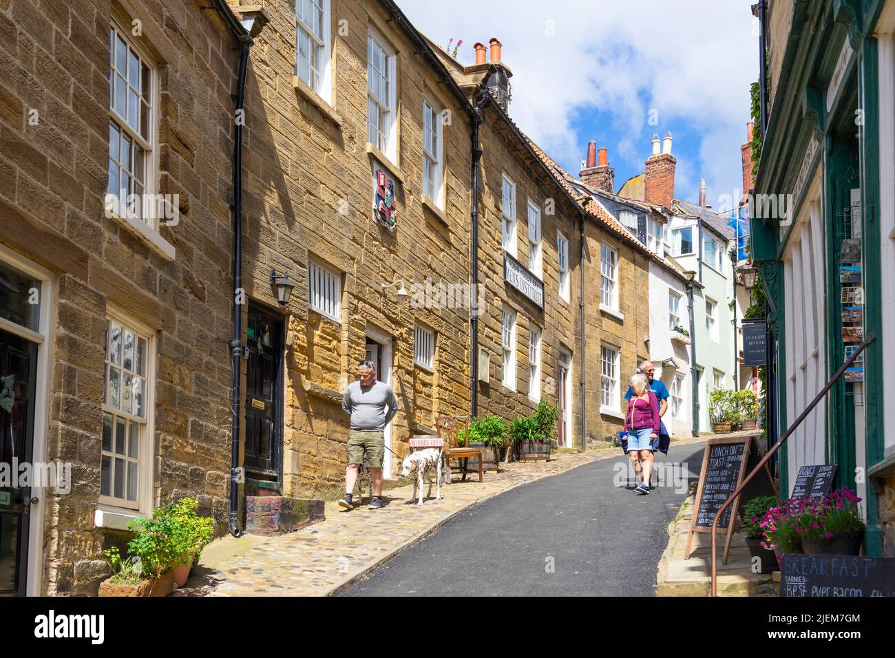Robin Hood's Bay Yorkshire Three people and a dog walking down the ...