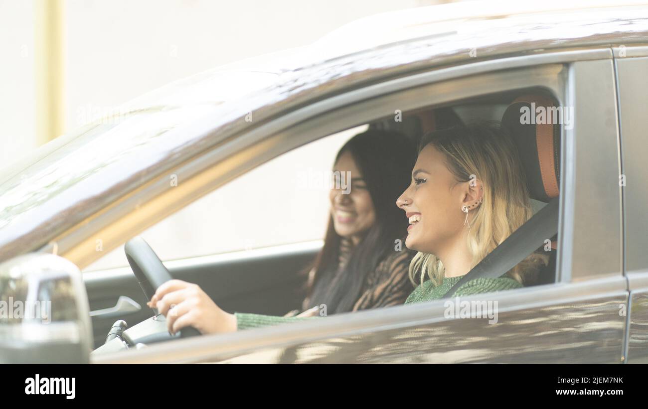 Two Young women smiling in a car enjoying a road tripping concept best ...