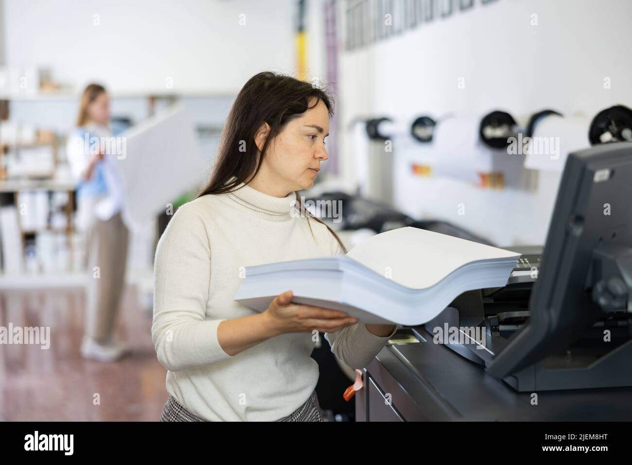 Woman loading ream of paper into printer Stock Photo - Alamy