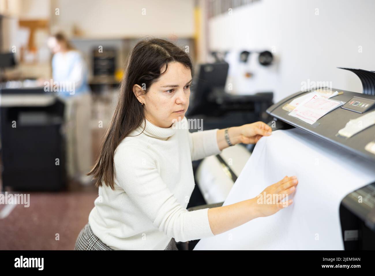 Woman employee of printing house works on modern printer Stock Photo ...