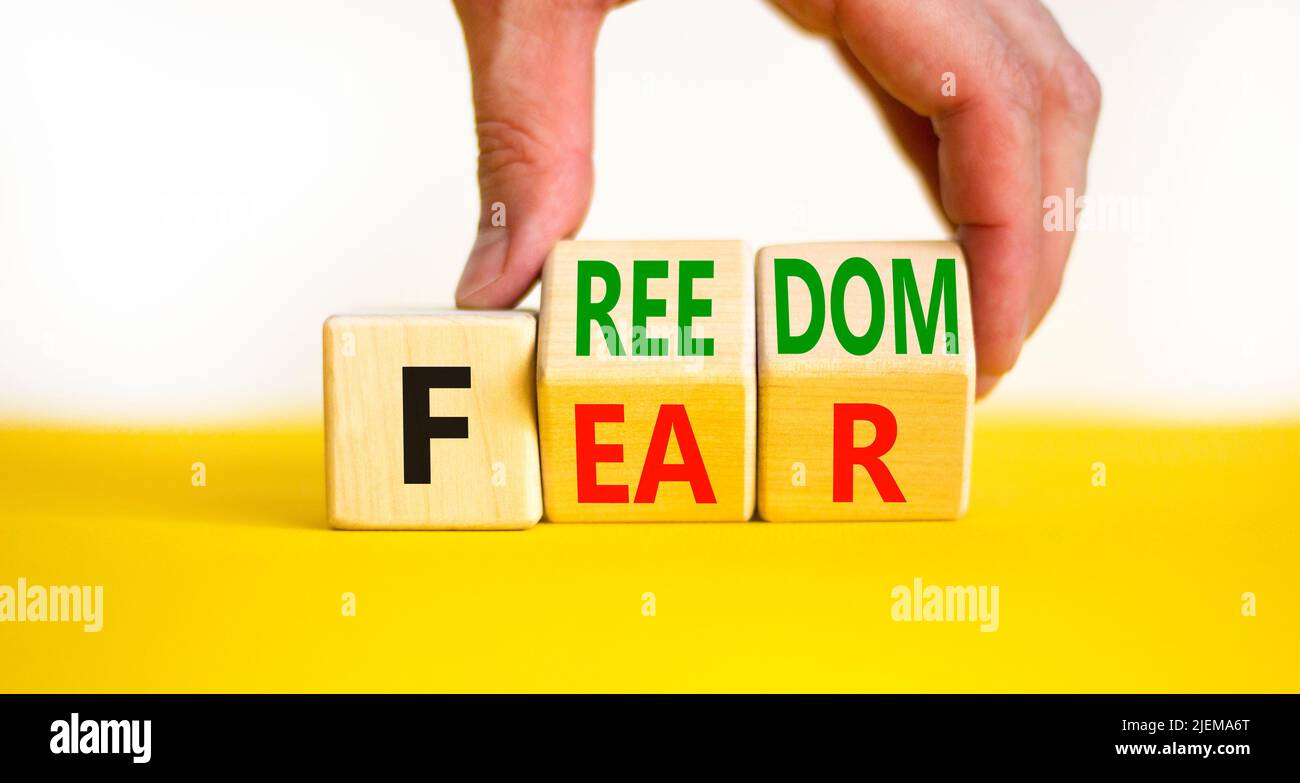 Freedom from fear symbol. Businessman turns wooden cubes and changes the concept word Fear to ...