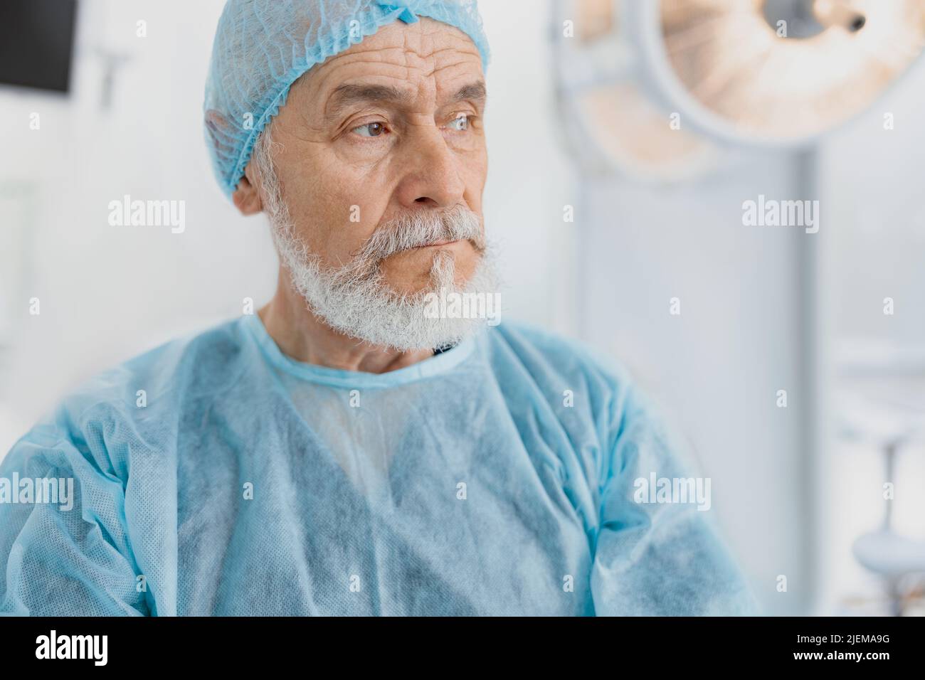 Senior surgeon in uniform standing in operating room, ready to work on ...