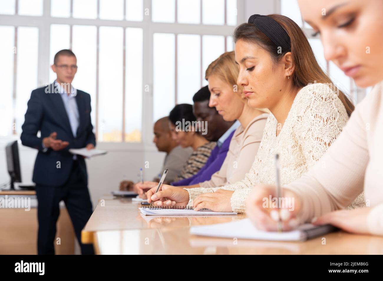 Side view of student group working on lecture in classroom Stock Photo ...