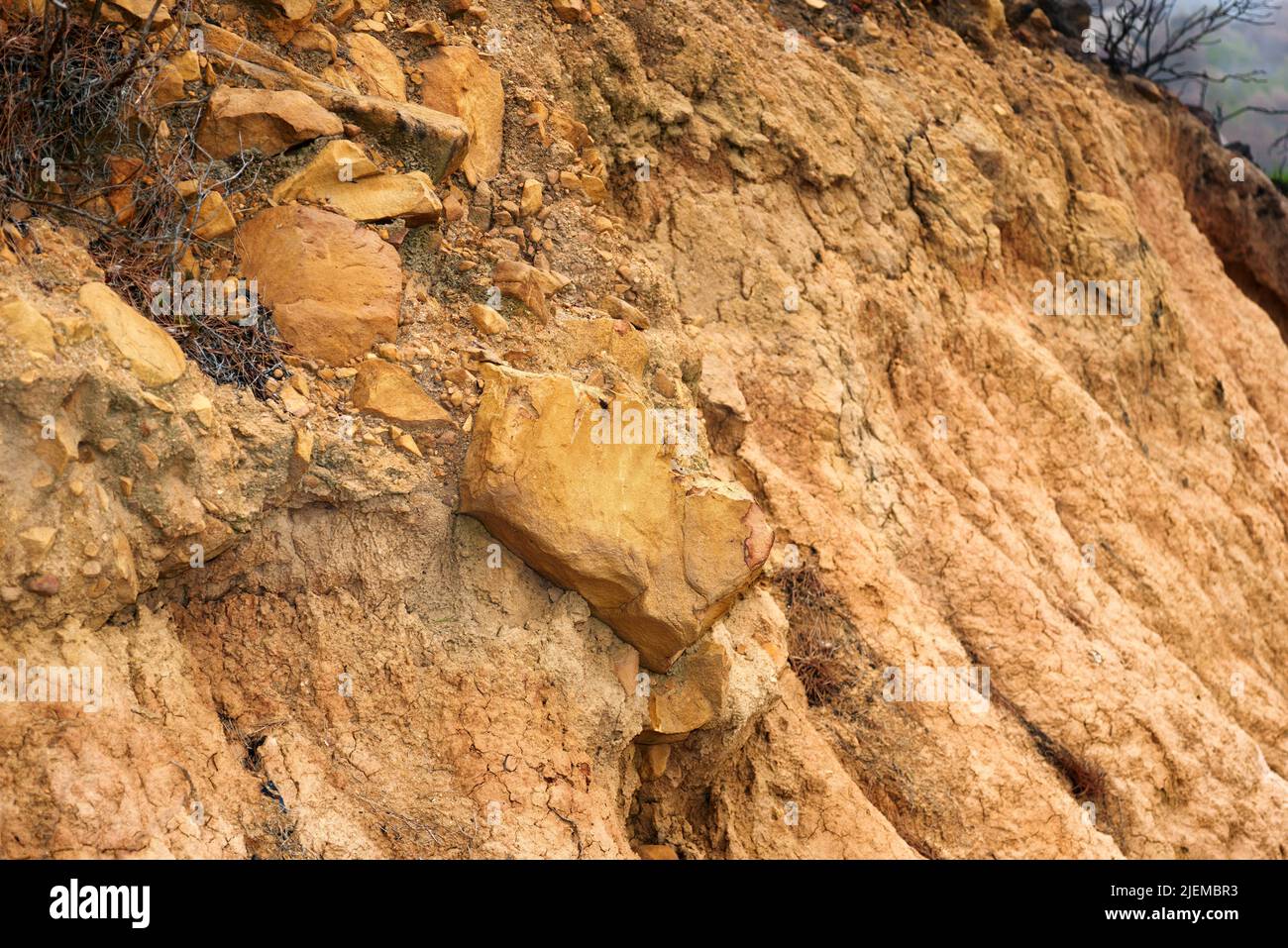Closeup of crumbling dirt mountainside. Brown textured stone or clay ...