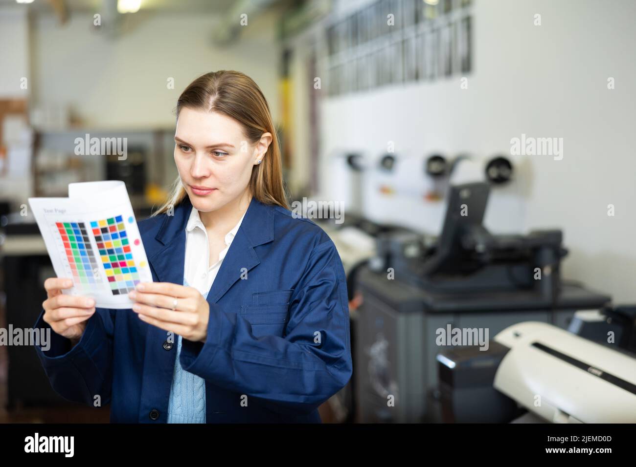Printing office worker examining test page for printer Stock Photo - Alamy