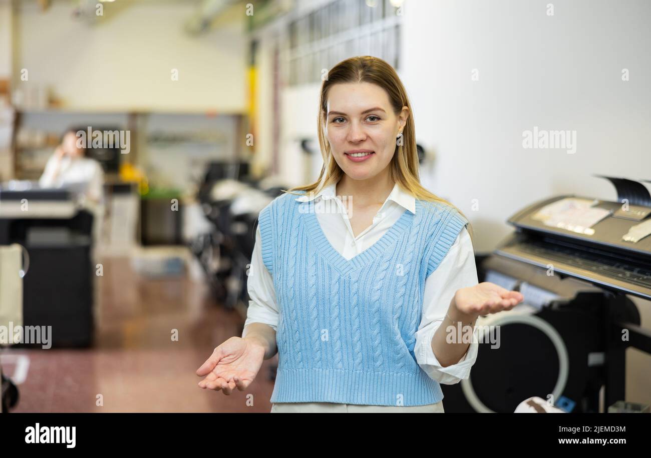 Friendly print shop employee invites customer to come inside Stock ...