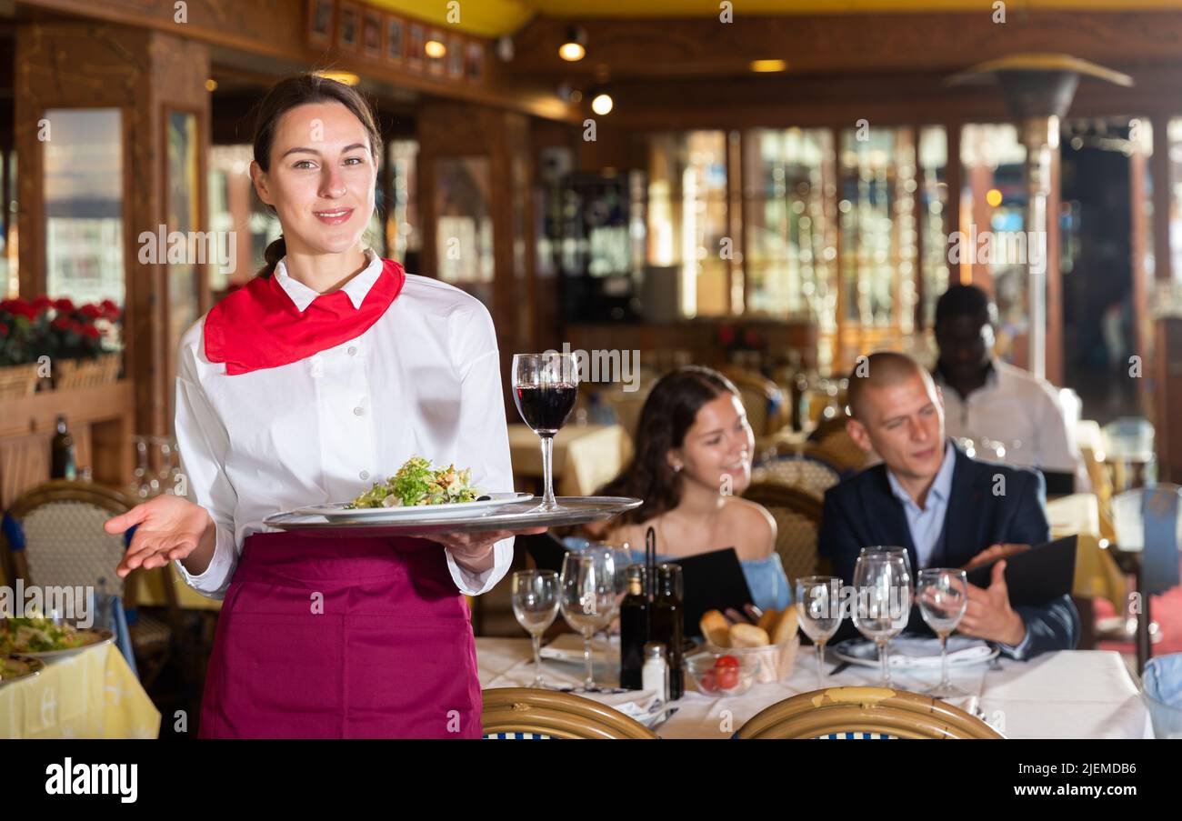 Professional attractive female waiter holding serving tray Stock Photo ...