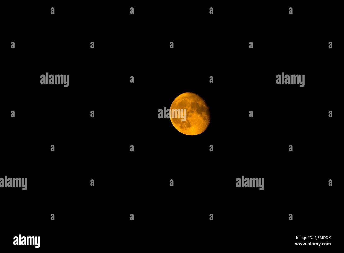 Full blood red moon in a city sky, tv antennas are visible in the ...