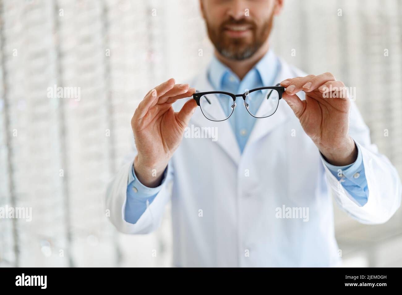 Male optician on a background of shop windows with different models of ...