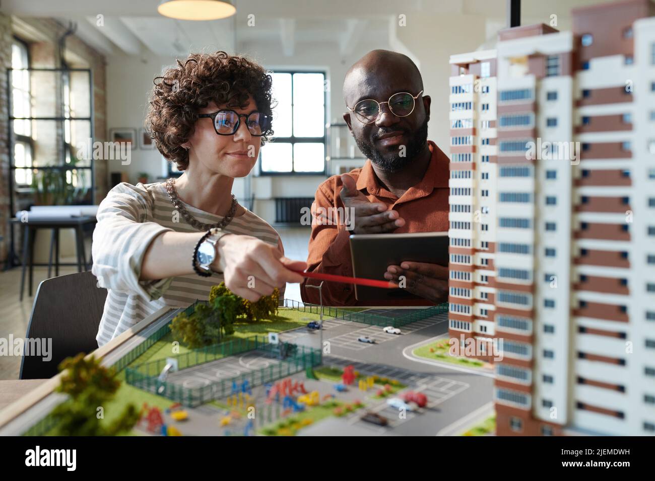 Two architects discussing construction mock-up of building together ...