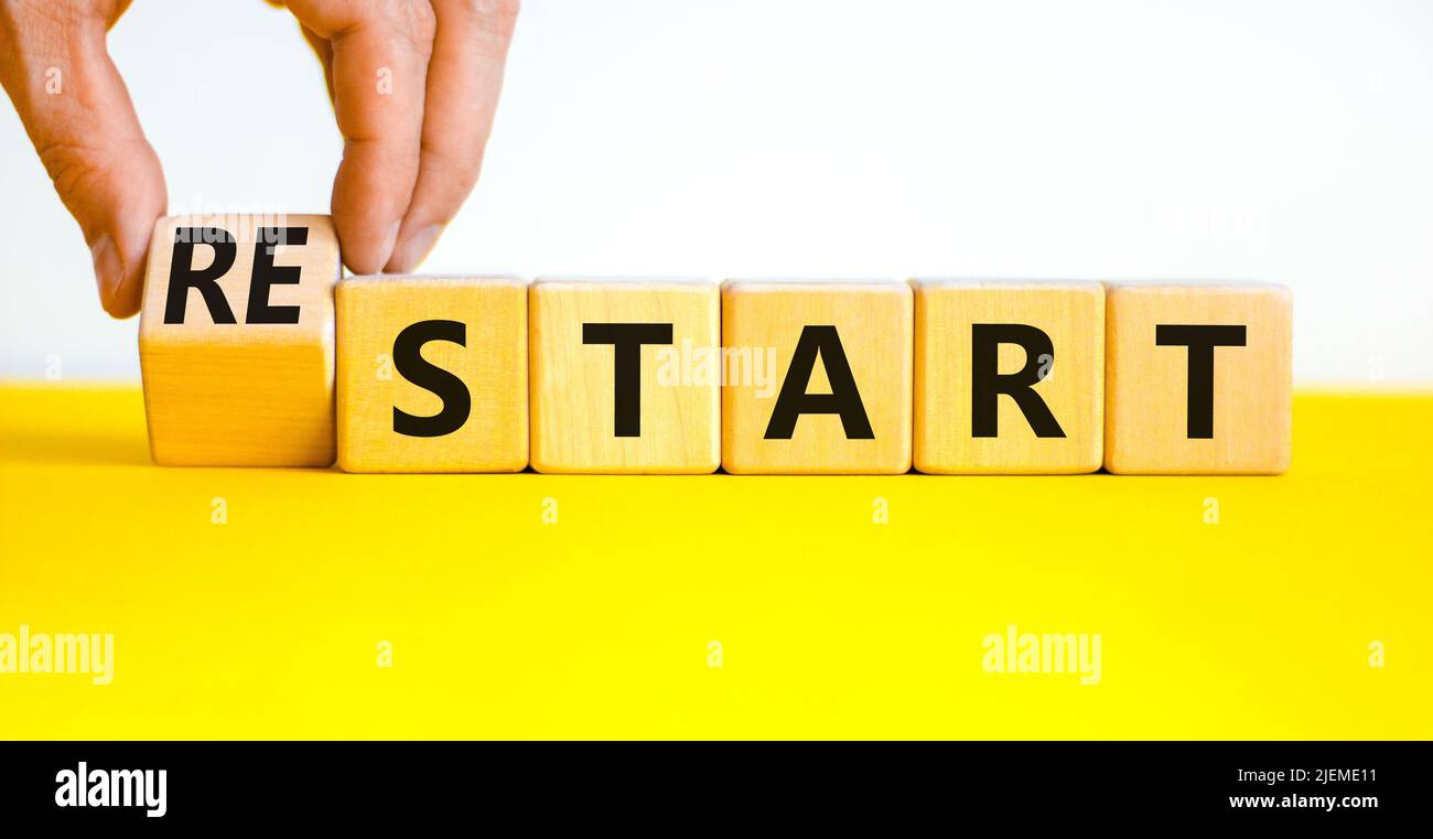 Start or restart symbol. Businessman turns wooden cubes and changes the ...