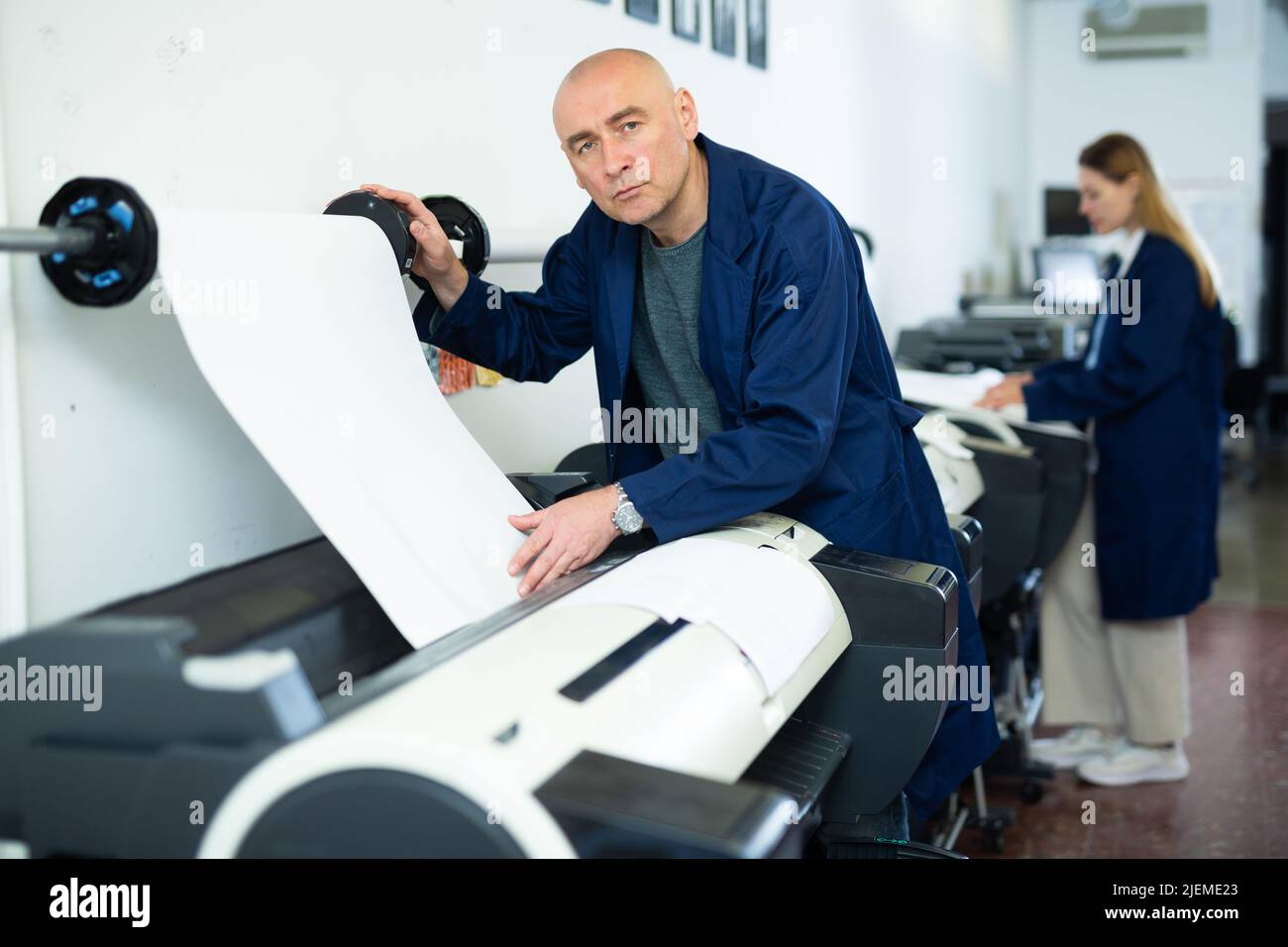 Man working in printing office, using printer Stock Photo - Alamy