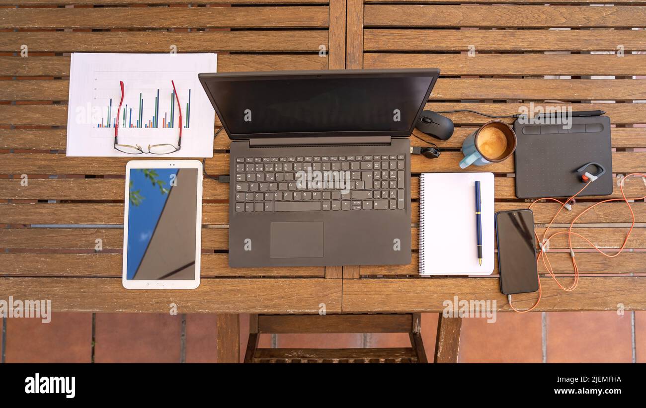 Teleworking at home from the garden with laptop and other gadgets ...