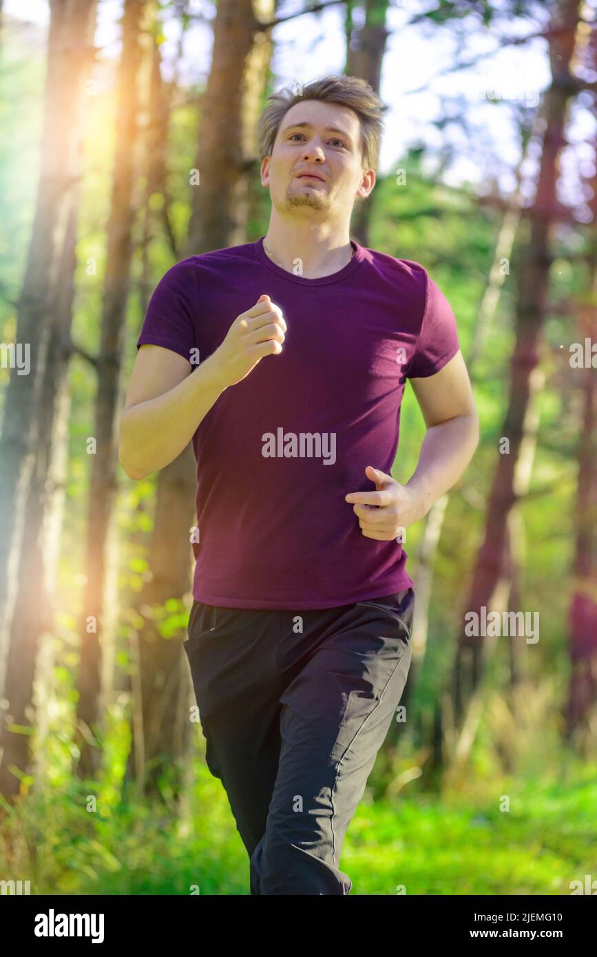 Running man jogging in city park at beautiful summer day. Sport fitness ...