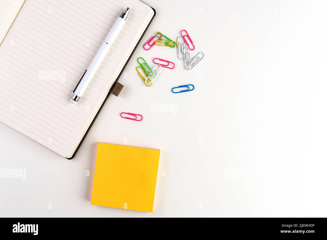 White office desk with open notebook, pen, colorful stickers, laptop ...