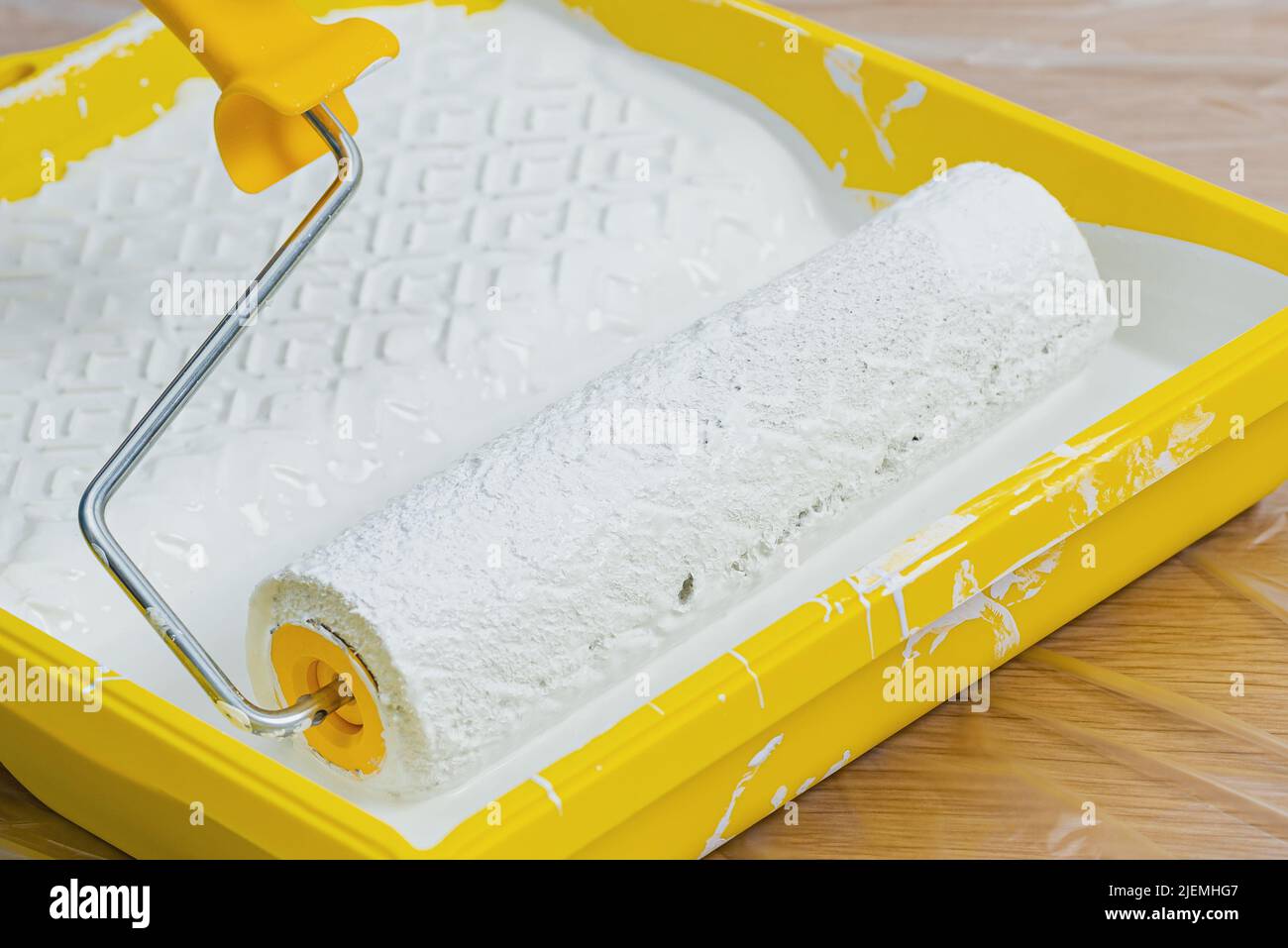 Paint roller in paint tray with white color. Repair and painting in the ...