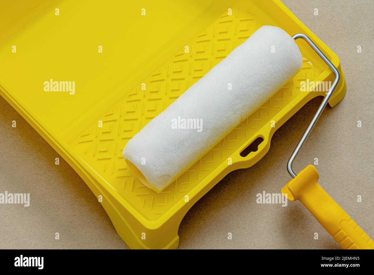 Paint roller in paint tray with white color. Repair and painting in the ...