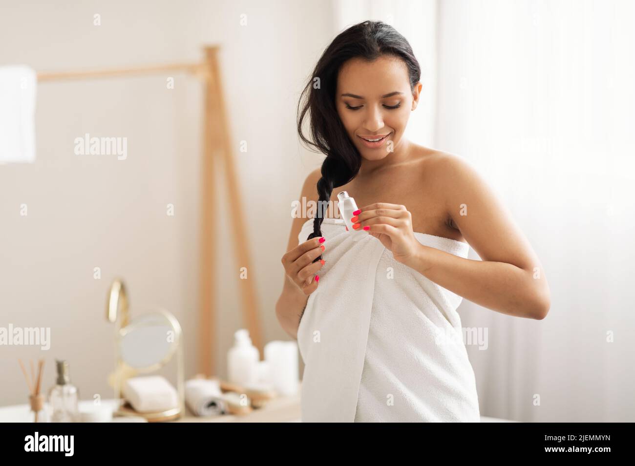 Cheerful Lady Applying Serum Caring For Hair In Bathroom Stock Photo ...