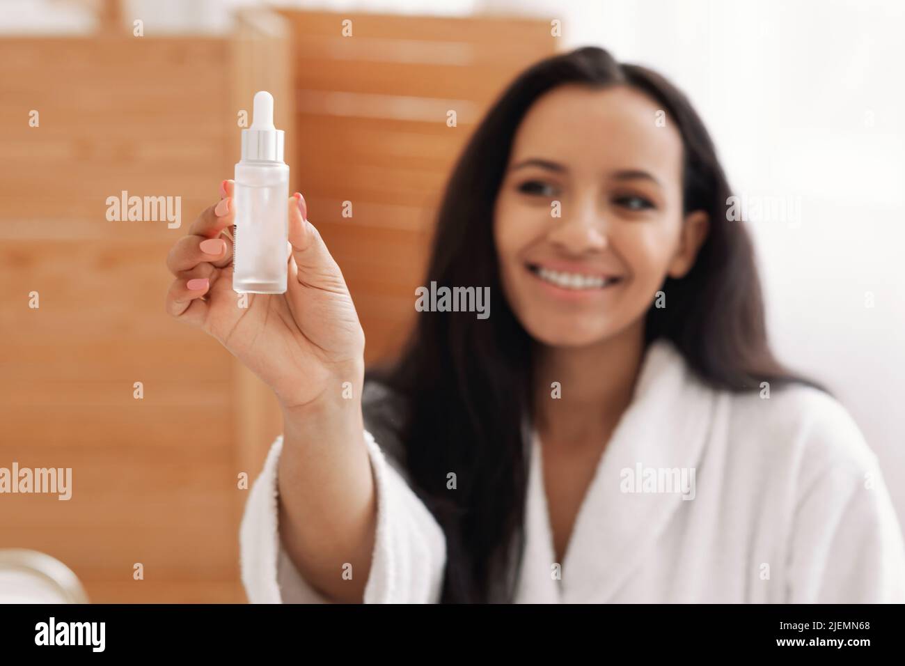 Black Lady Showing Cosmetic Bottle Advertising Facial Serum In Bathroom ...