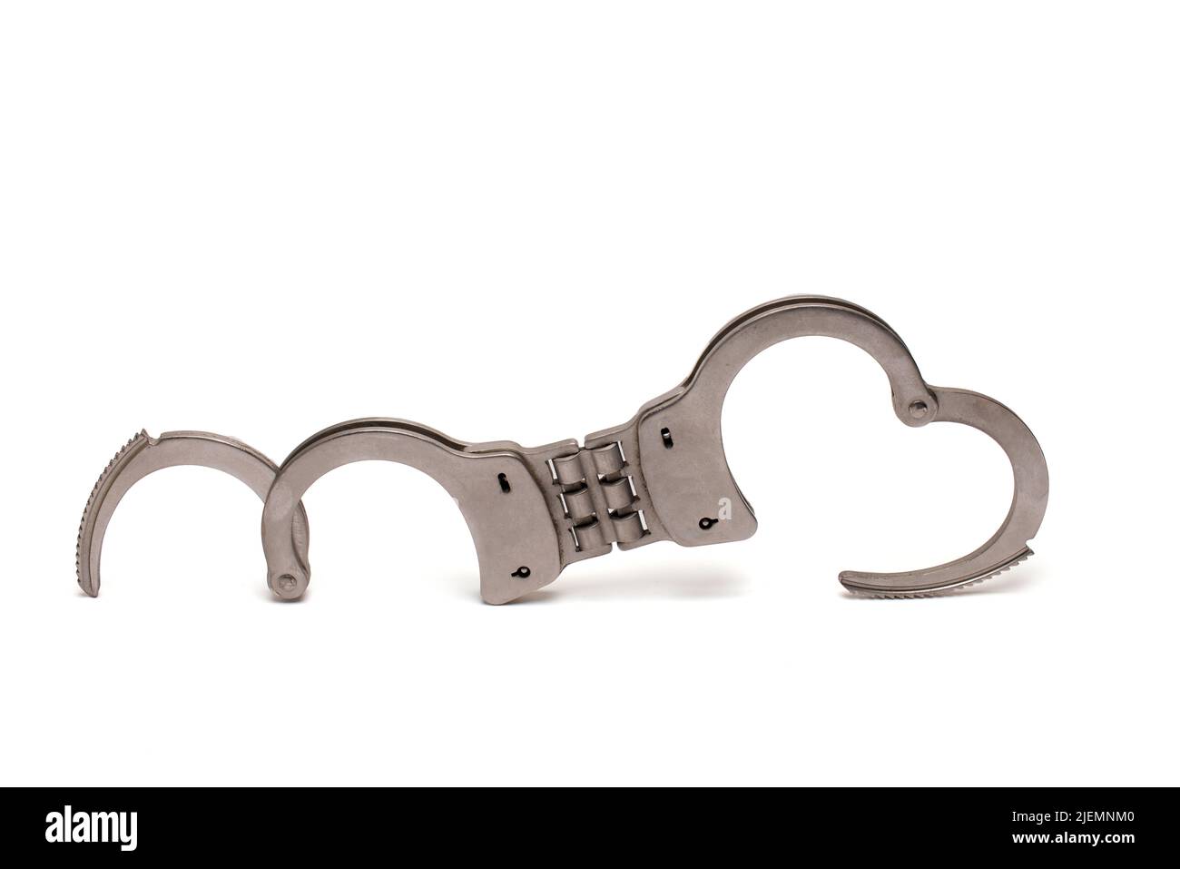 Close up of handcuffs lying open on white background as concept for ...