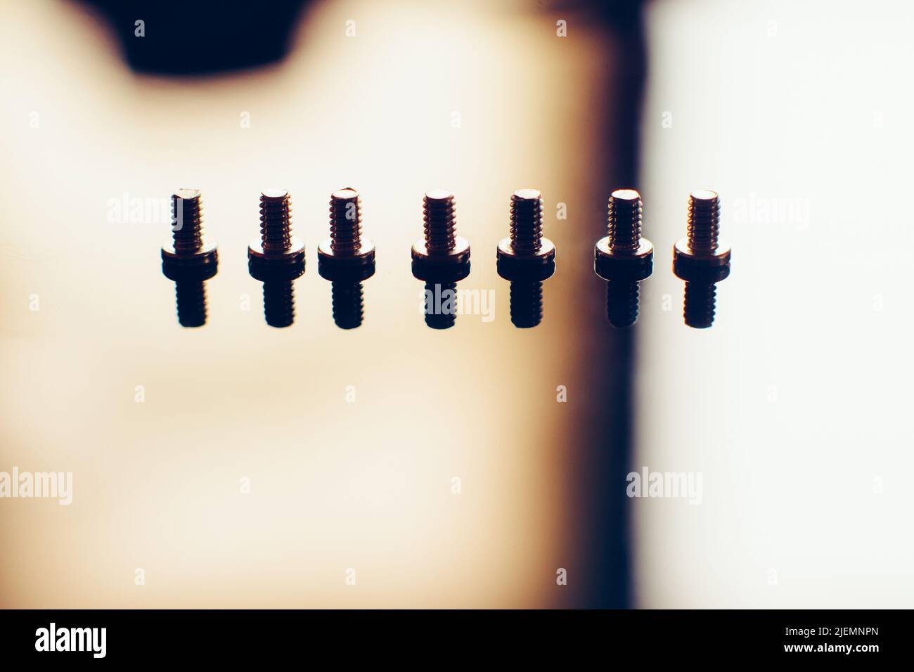 Skrew on mirror background in the row Stock Photo - Alamy