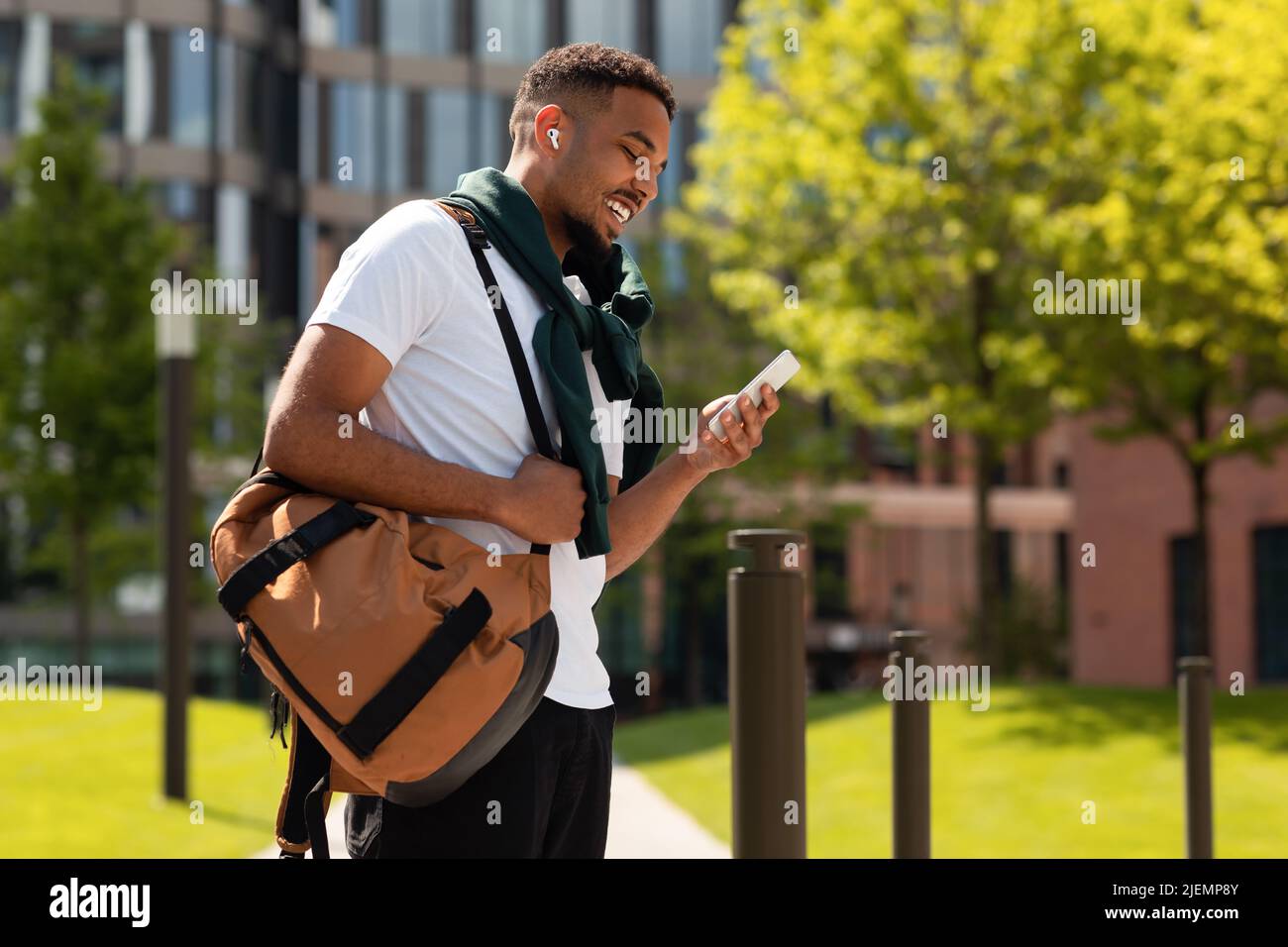 Tech gadgets for entertainment. Happy african american guy walking and ...