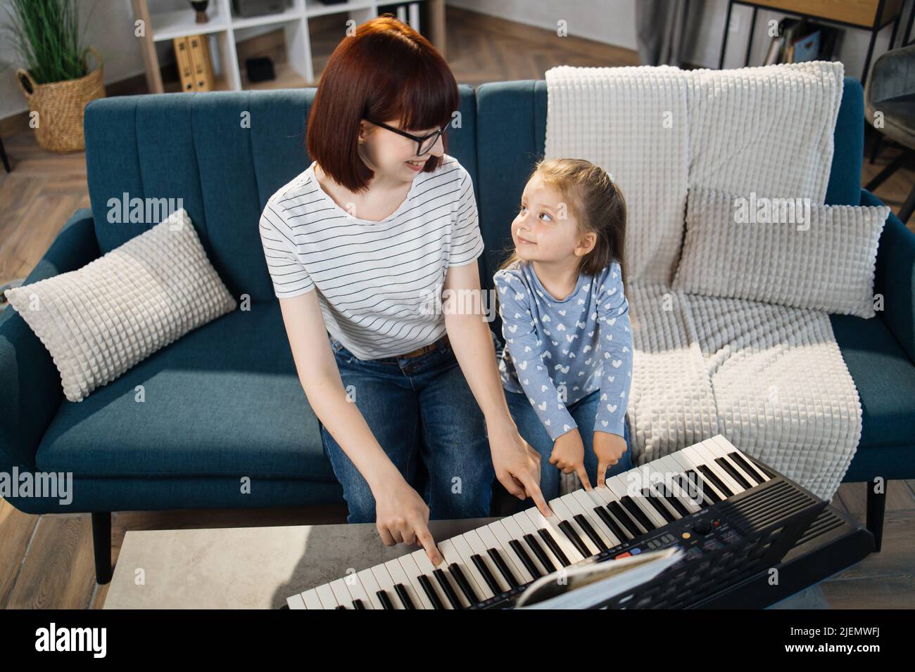 Little cute girl with music teacher having lesson at piano at school of ...