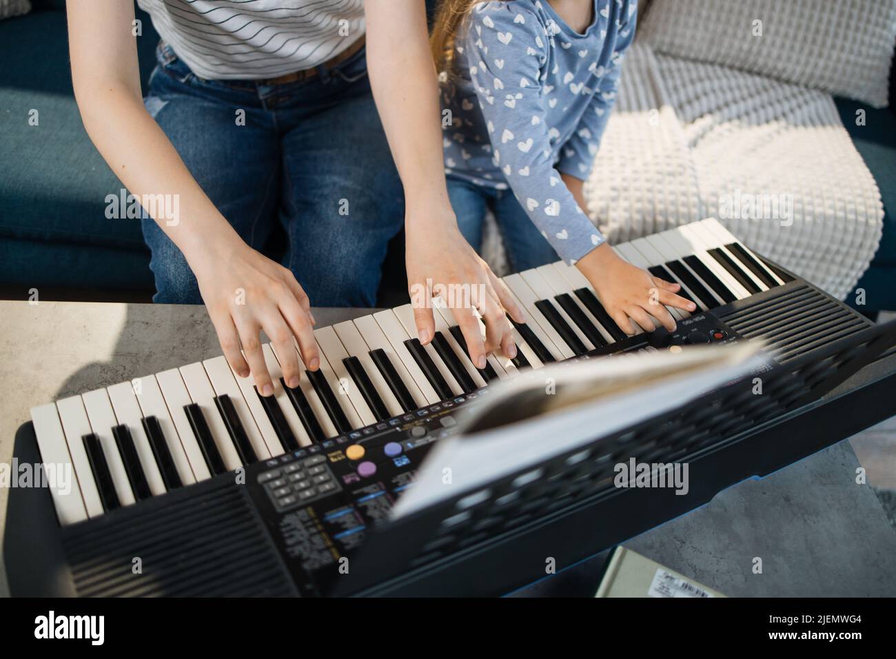 Close up of hands and piano keys. Little girl child learning to play ...