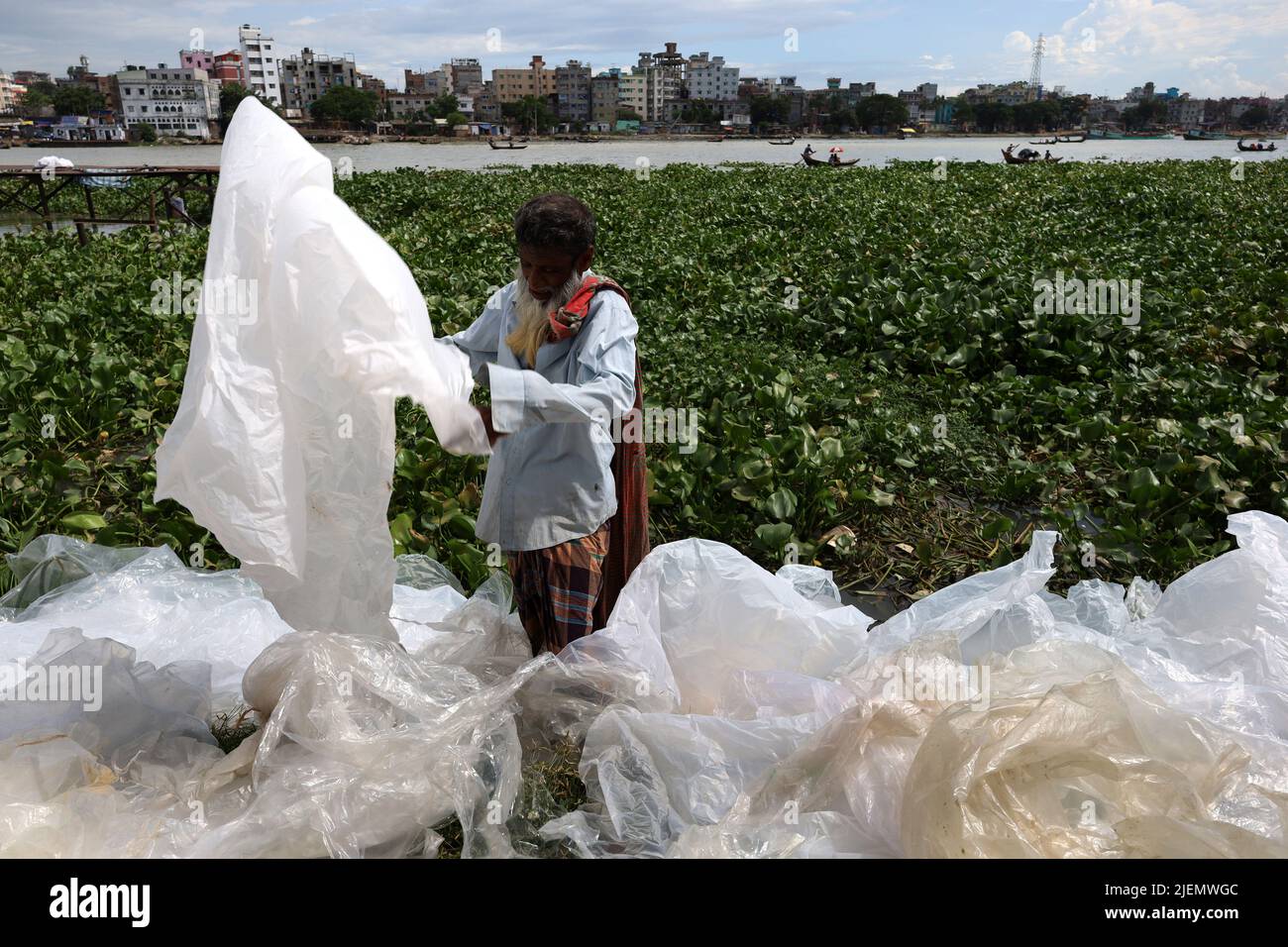Dhaka, Dhaka, Bangladesh. 27th June, 2022. A man washes dirty polythene ...